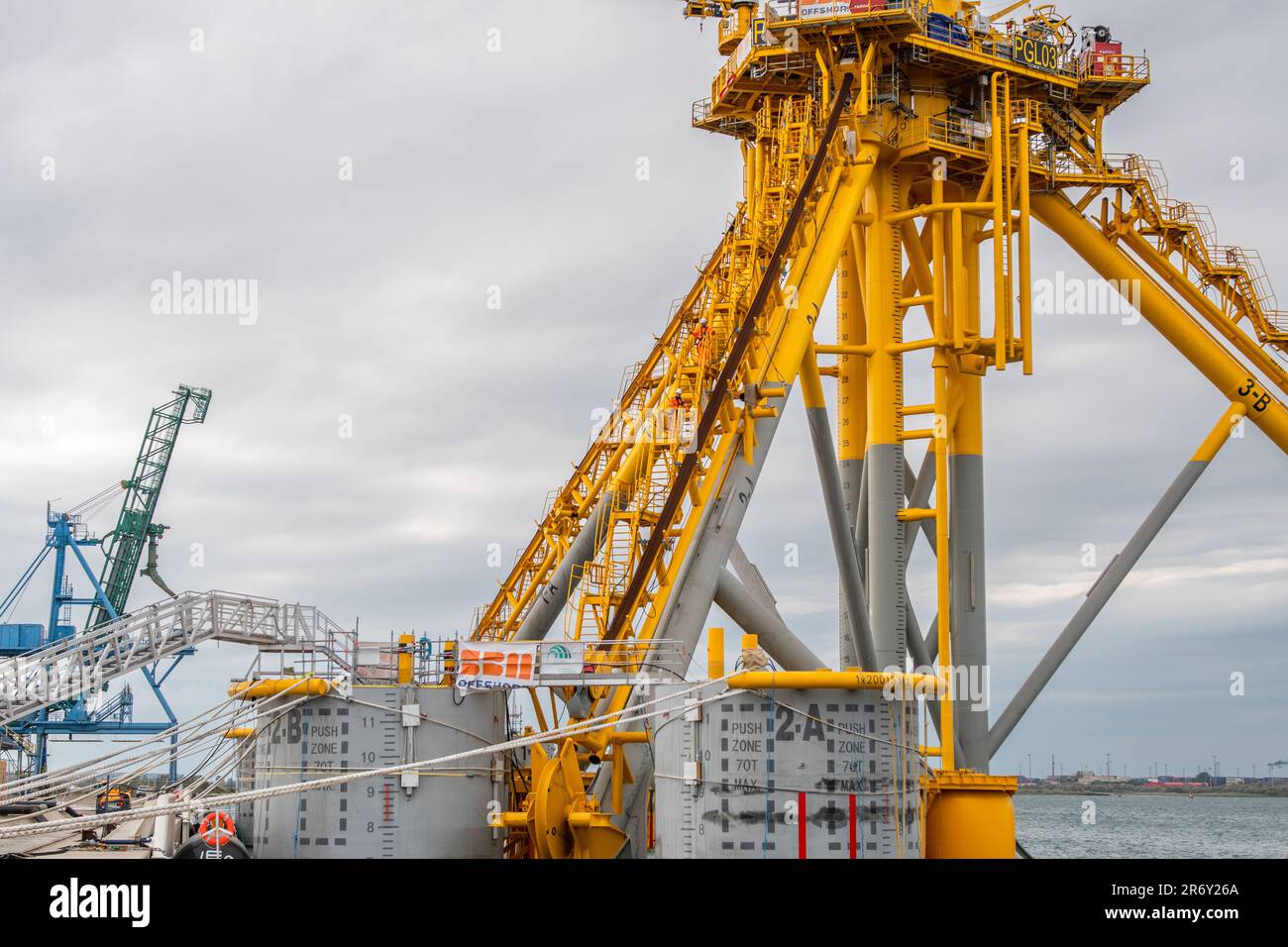Two workers climb to the top of the first float for an offshore wind ...