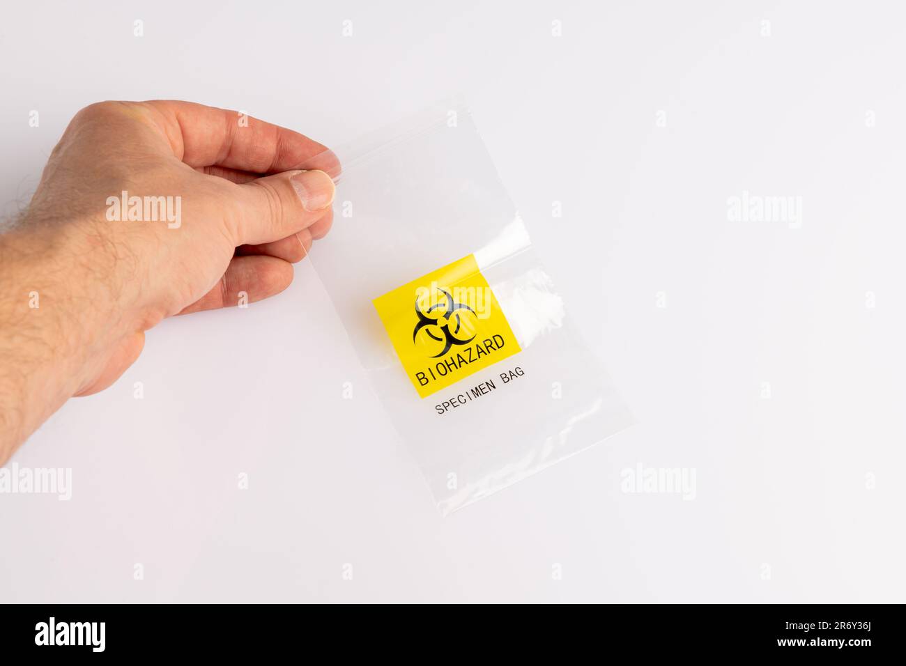 A hand holding biohazard specimen plastic bag on a white background ...