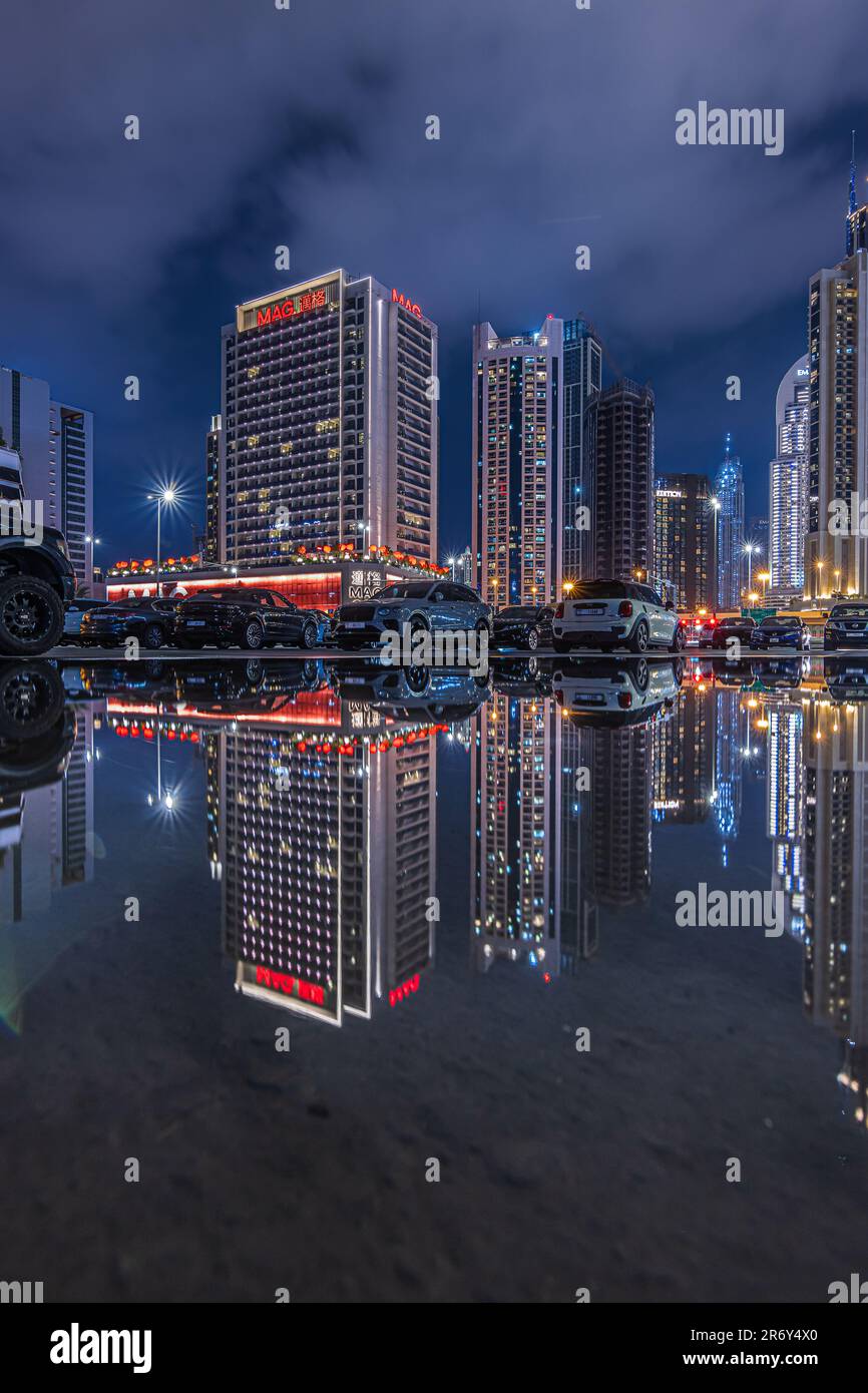 Skyscrapers of Dubai city skyline at blue hour. Reflections with parked ...