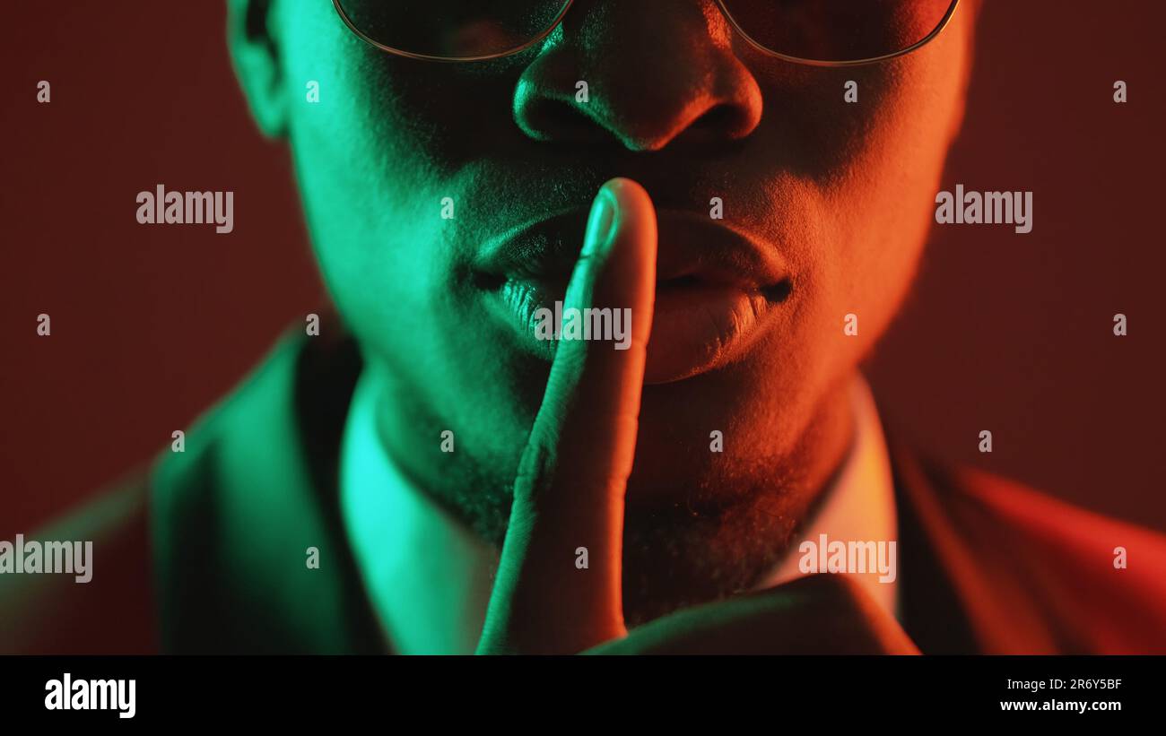 Shush gesture. Man secret. Confidential conspiracy. Green red neon ...