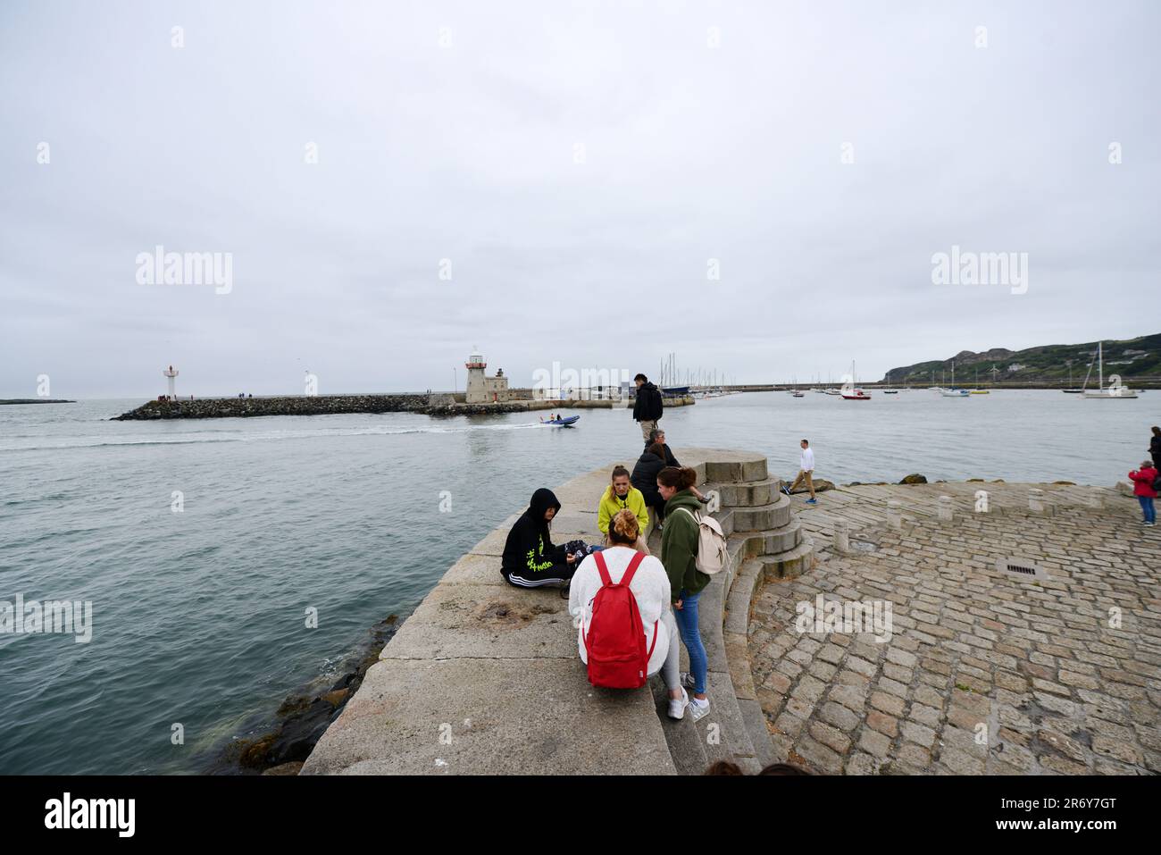 Tourist enjoying the views of the lighthouse and the harbour of Howth ...