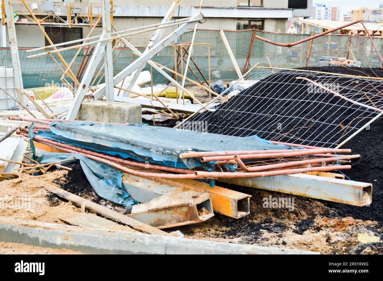 A mess at a construction site with scattered building materials and ...