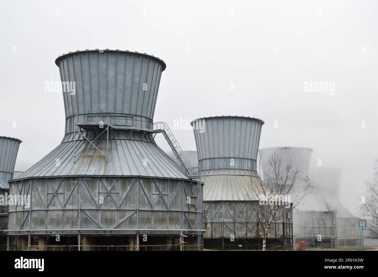 Large cooling towers in water and fog at an oil refinery, petrochemical ...