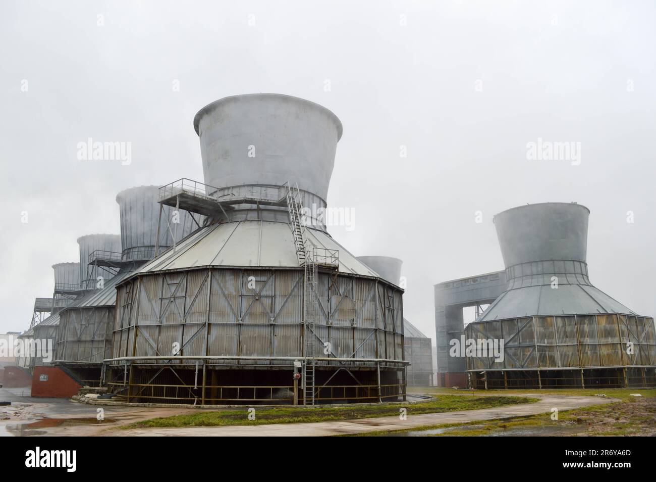Large cooling towers in water and fog at an oil refinery, petrochemical ...