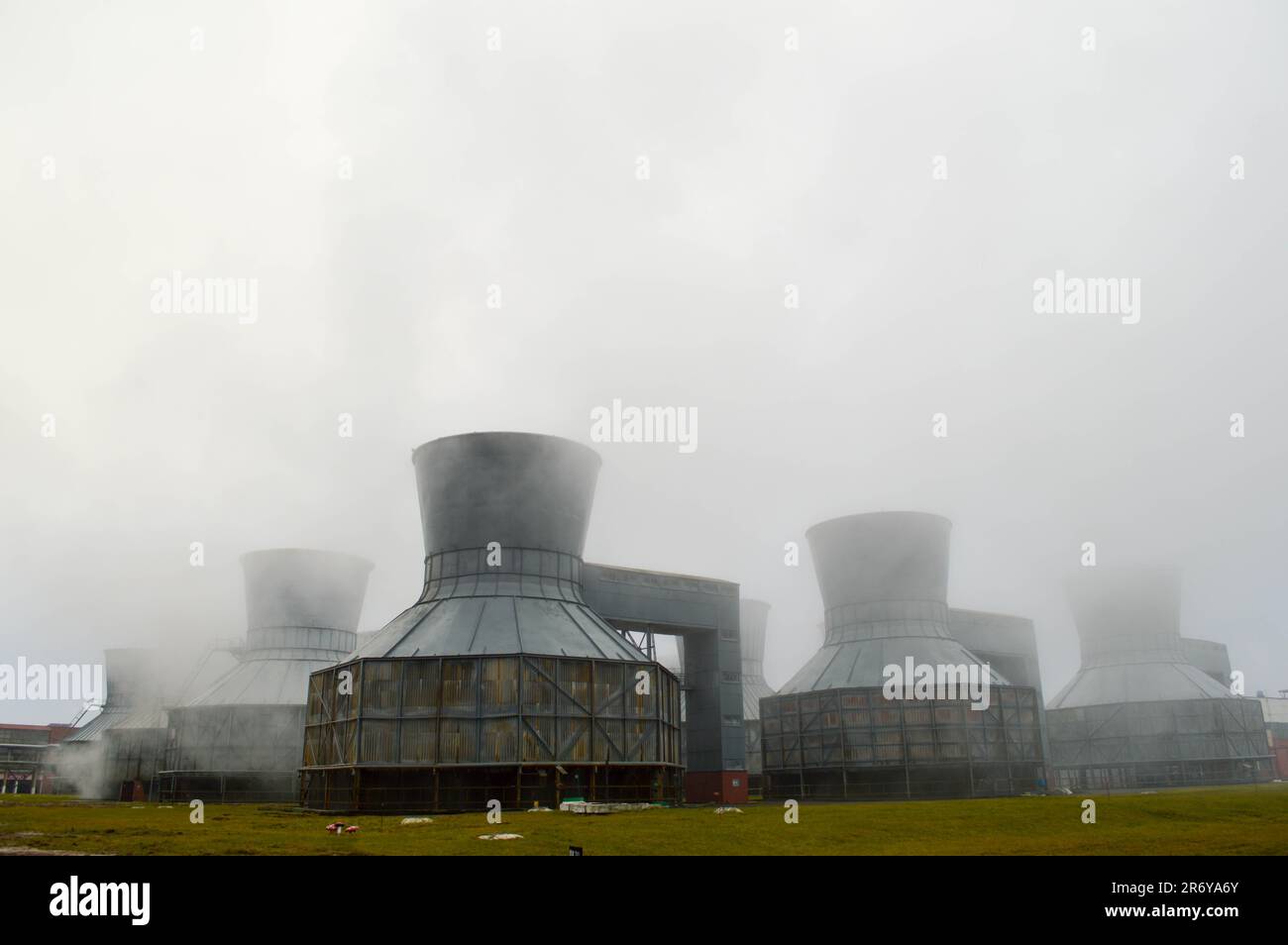 Large cooling towers in water and fog at an oil refinery, petrochemical ...