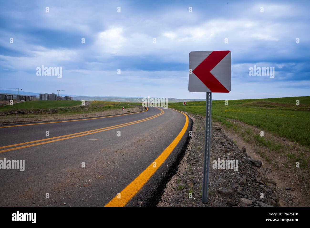 Newly Paved High-Quality Winding Road with Yellow Lines and Turn Sign ...