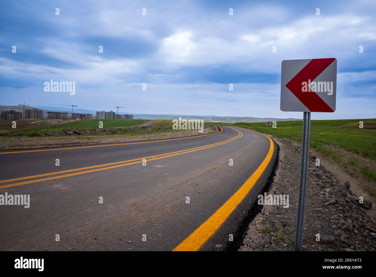 Newly Paved High-Quality Winding Road with Yellow Lines and Turn Sign ...