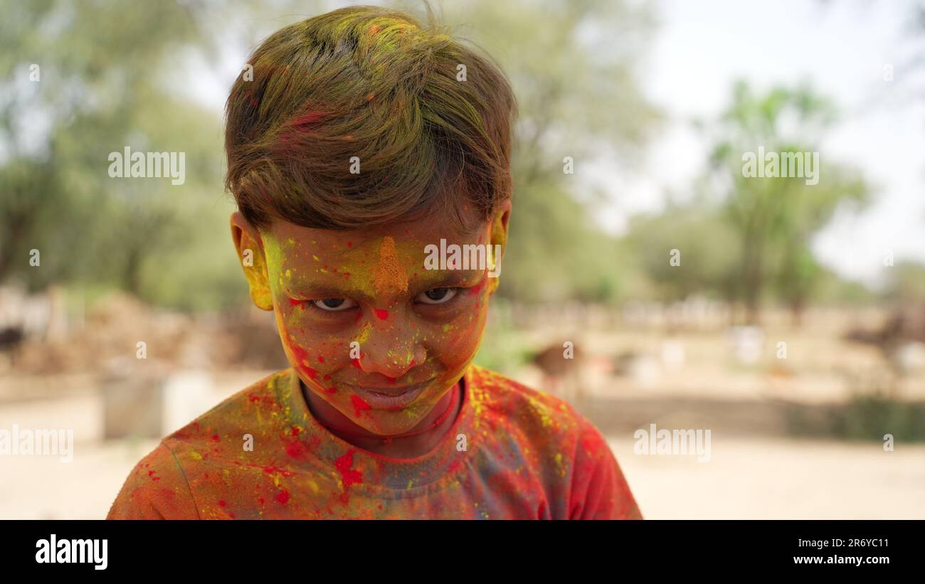 Colorful funny face of indian child in holi festival. Holi celebrations ...