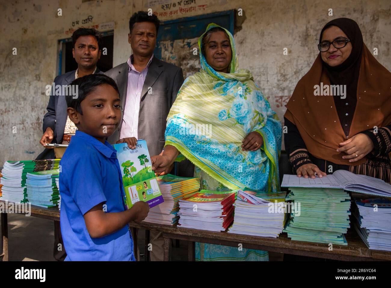 A student receives new textbook for the new academic year from teachers at a primary school at ...
