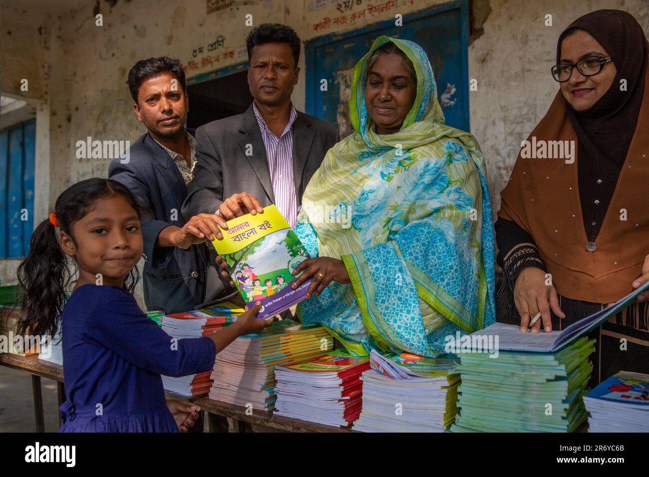 A student receives new textbook for the new academic year from teachers at a primary school at ...