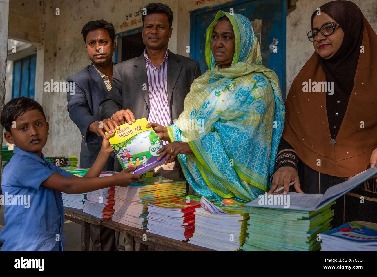A student receives new textbook for the new academic year from teachers at a primary school at ...