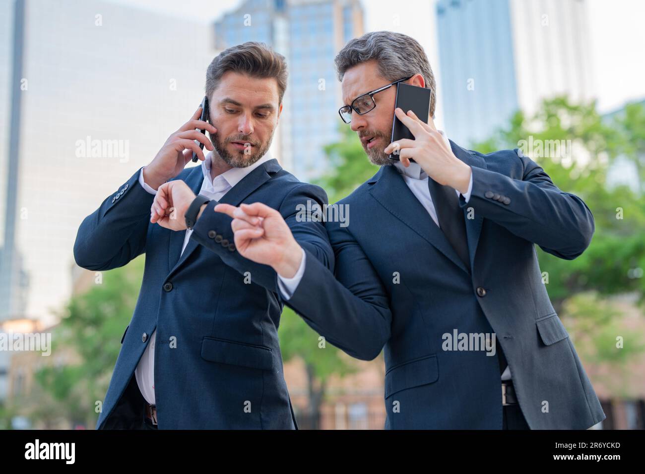 Caucasian employee on urban background office building texting messages ...