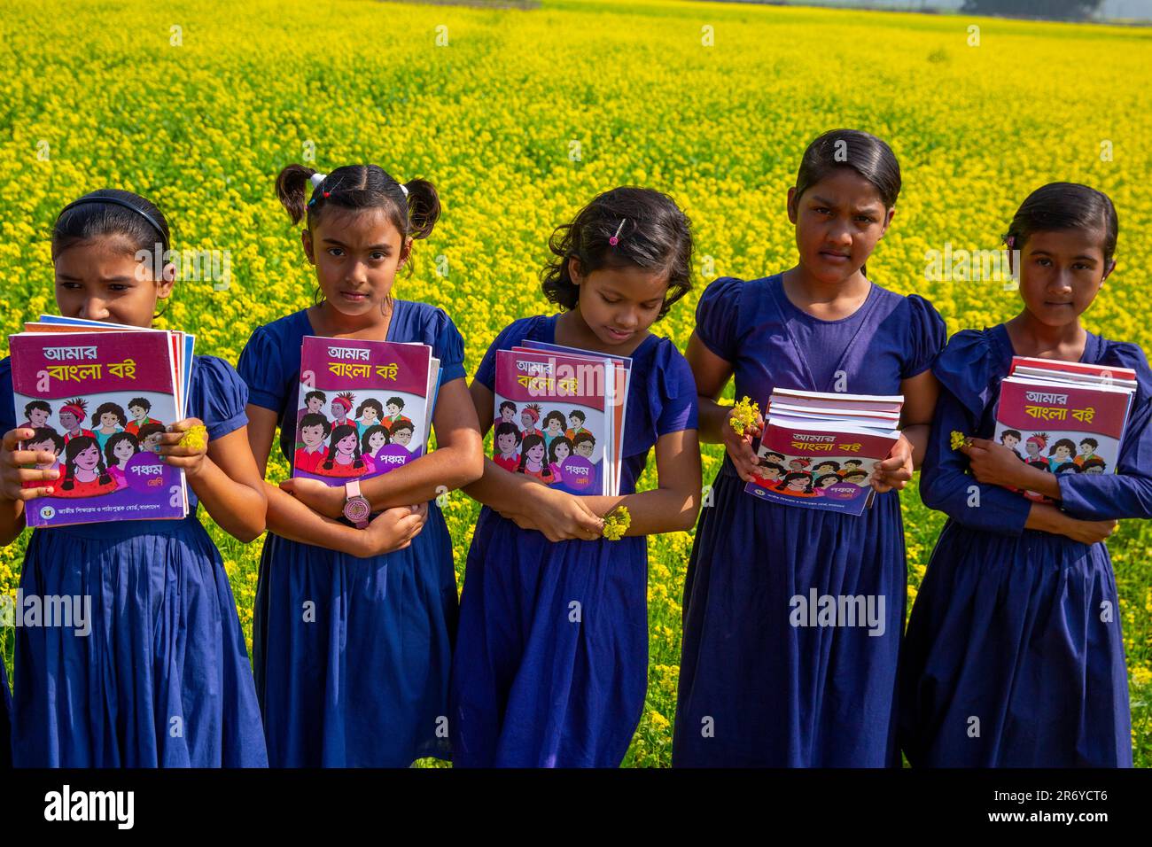 Bangladeshi primary school students hold new textbooks after receiving ...