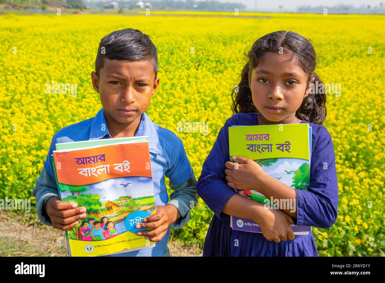 Bangladeshi primary school students hold new textbooks after receiving ...