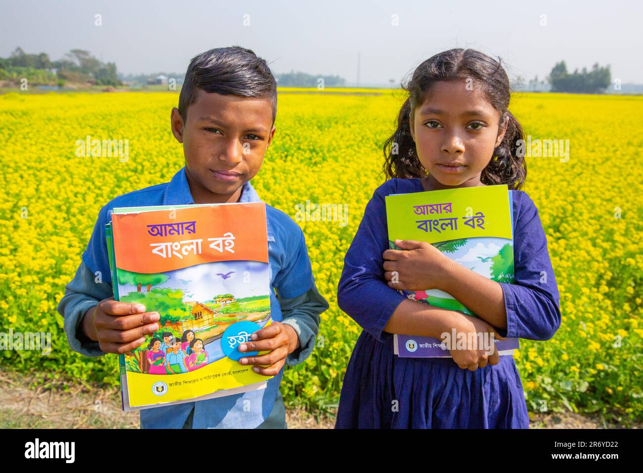 Bangladeshi primary school students hold new textbooks after receiving them for the new classes ...