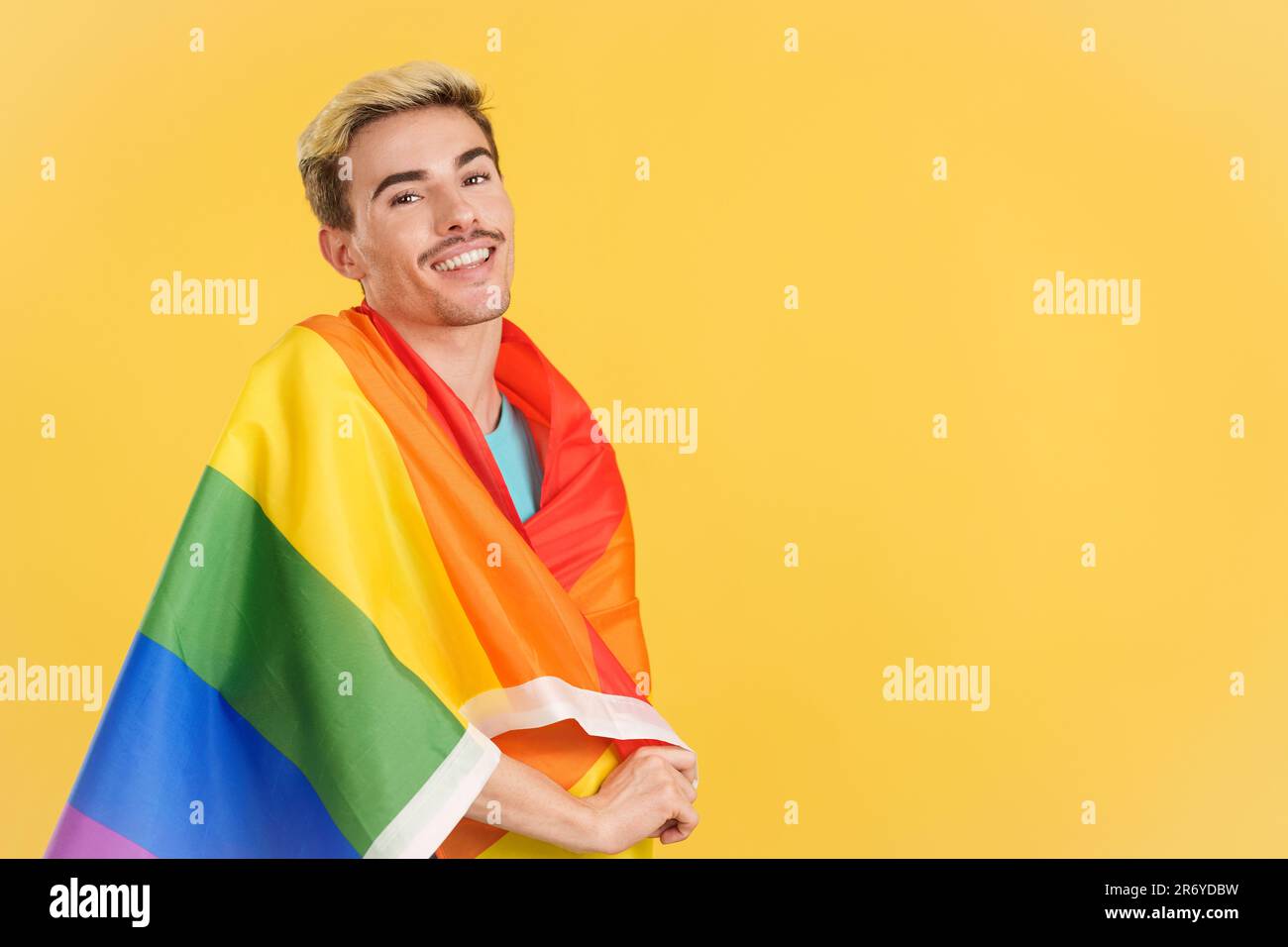 Happy gay man wrapped with a lgbt flag Stock Photo - Alamy