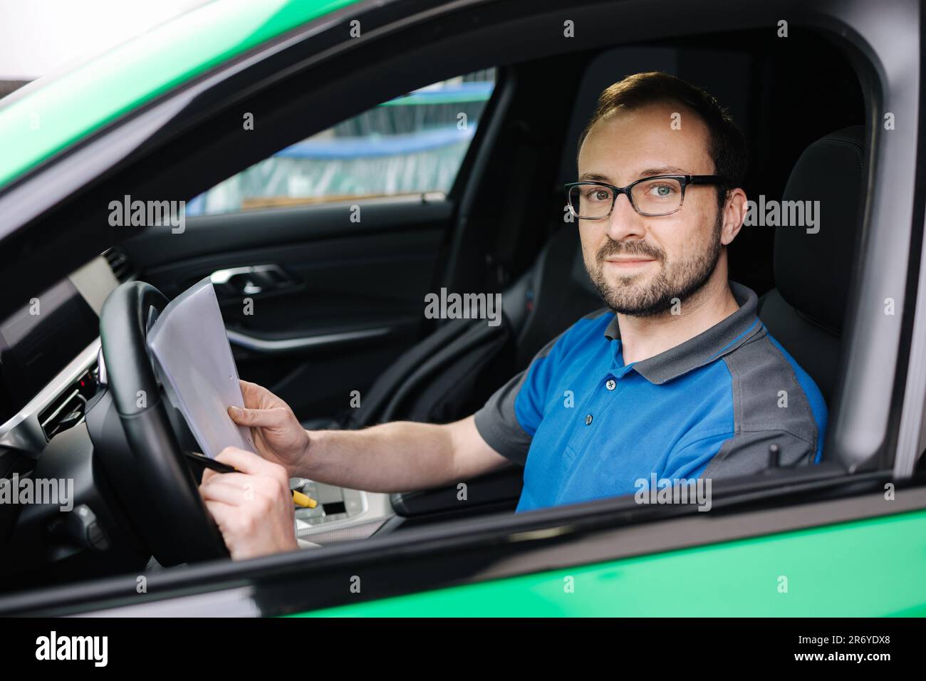 Side view on male mechanic fill document during car inspection. Man ...
