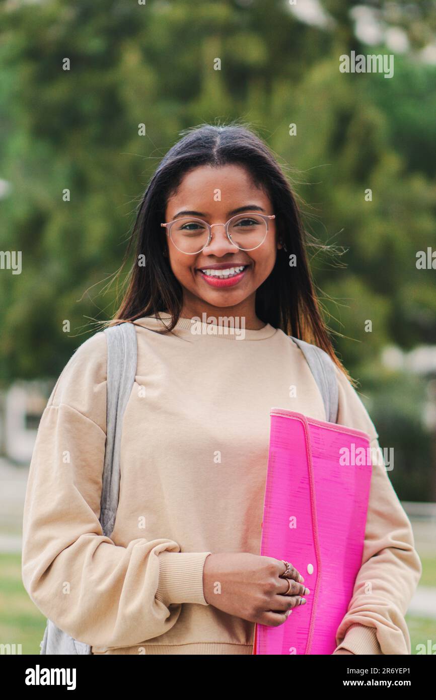 Vertical individual portrait of a happy hispanic smart school girl with ...