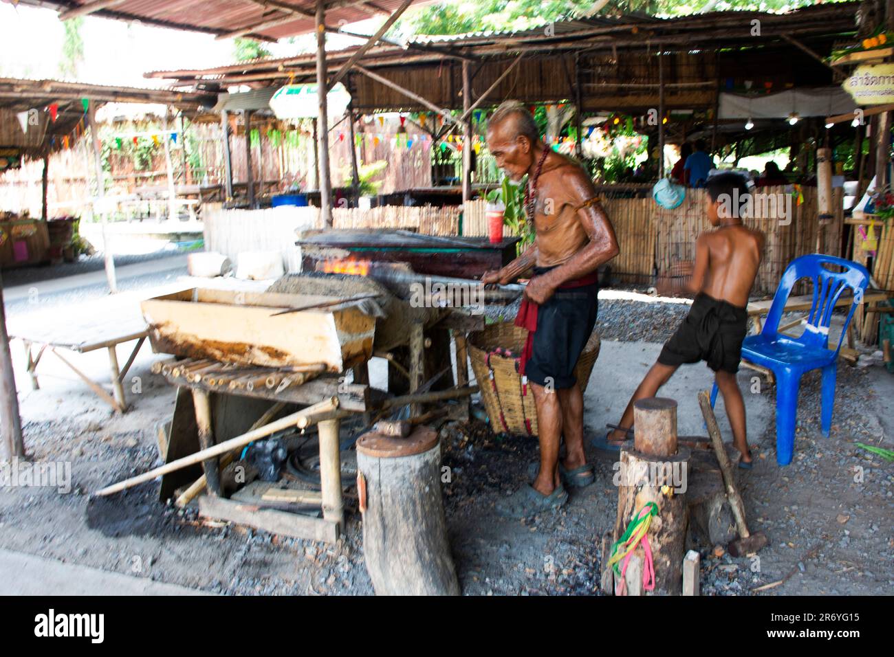 Thai oldman people blacksmith or metalsmith making ancient iron armor ...