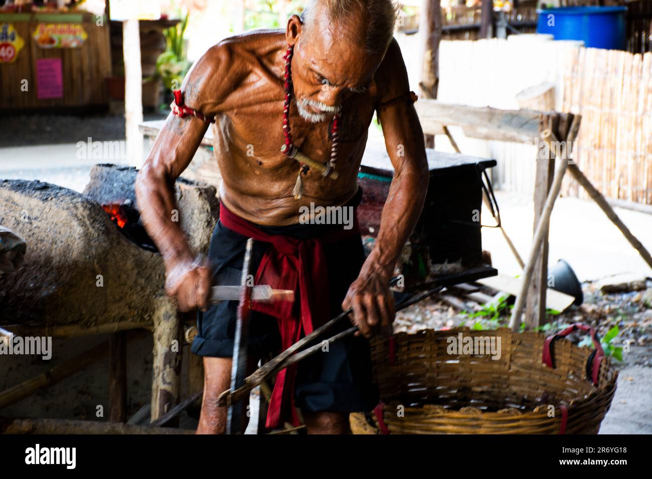 Thai oldman people blacksmith or metalsmith making ancient iron armor ...