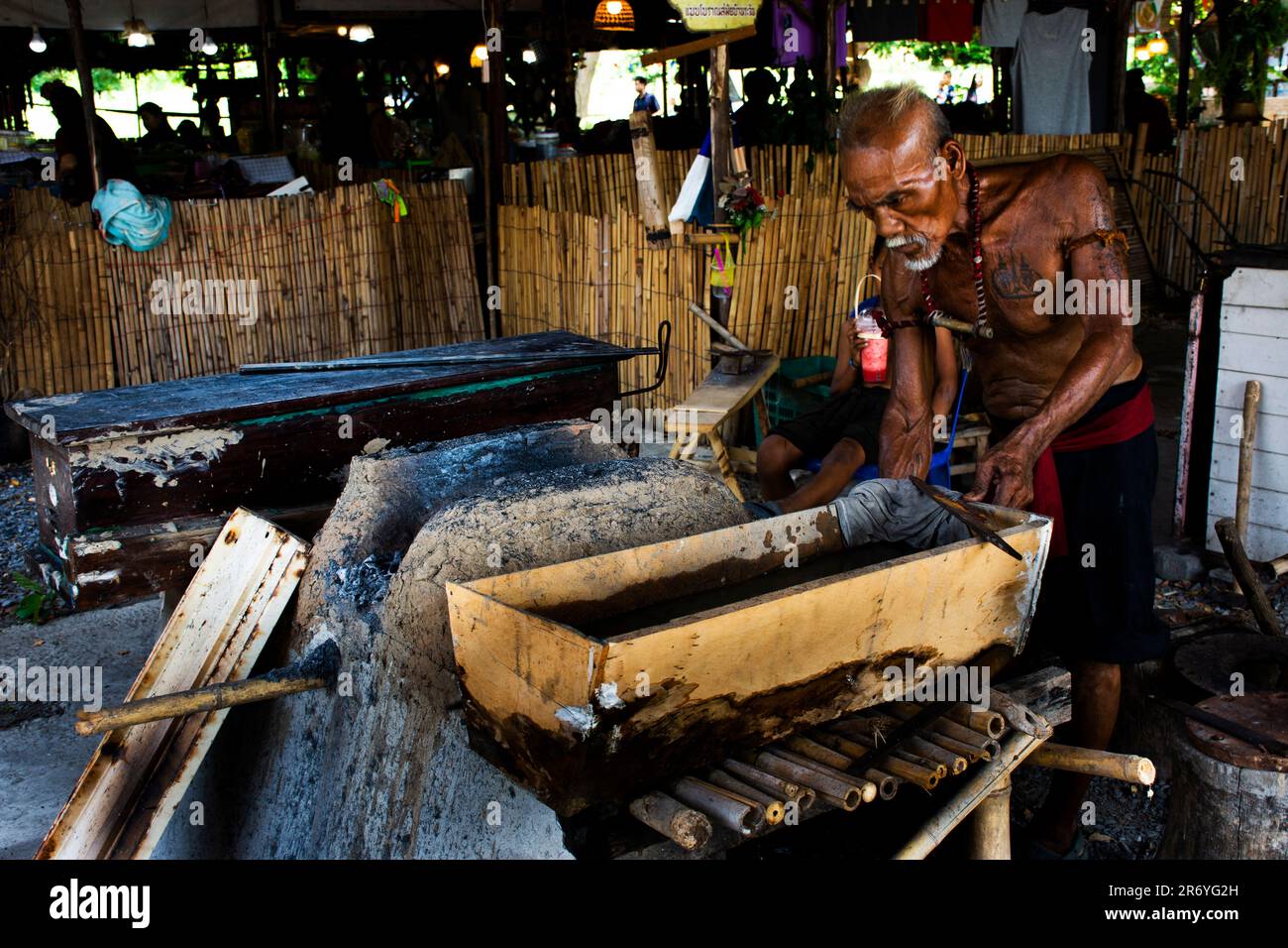Thai oldman people blacksmith or metalsmith making ancient iron armor ...