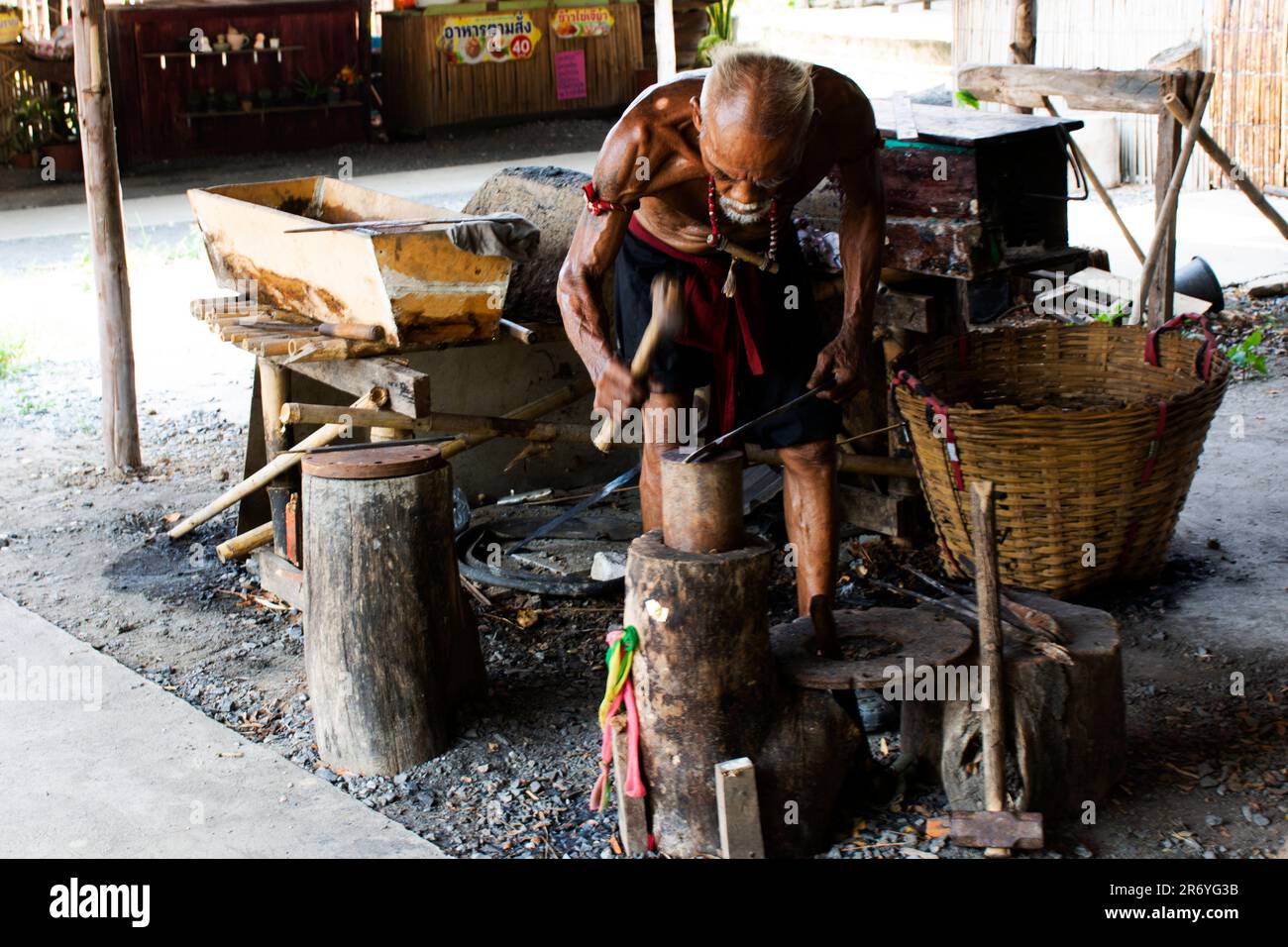 Thai oldman people blacksmith or metalsmith making ancient iron armor ...