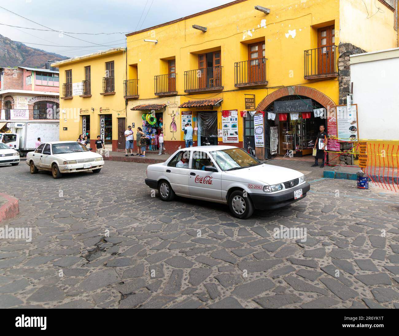 Cars driving on cobbled street in town of Tepoztlán, State of Morelos ...