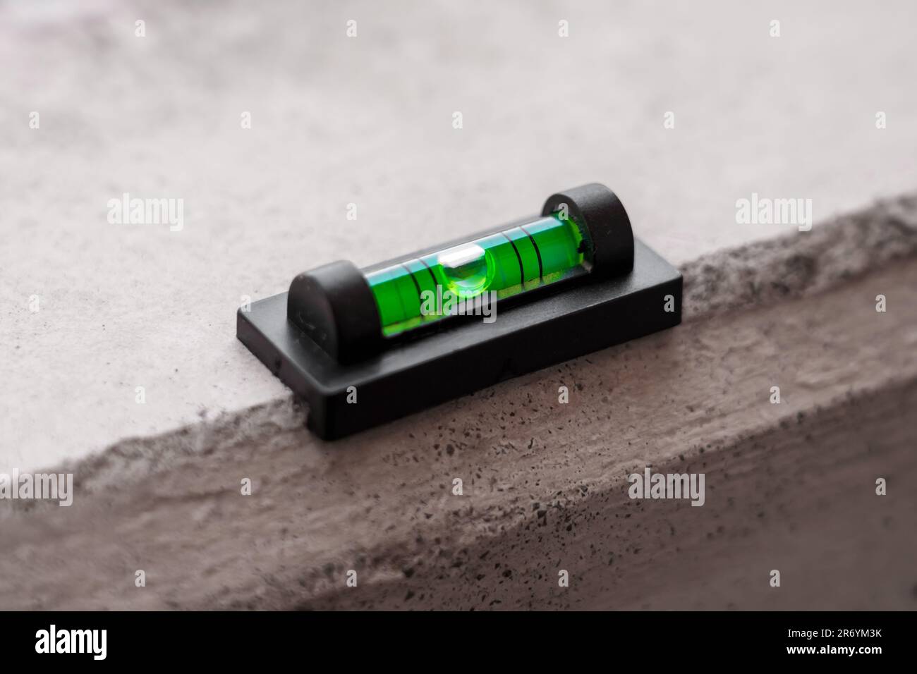 Construction spirit level tool with green bubble on a concrete surface ...