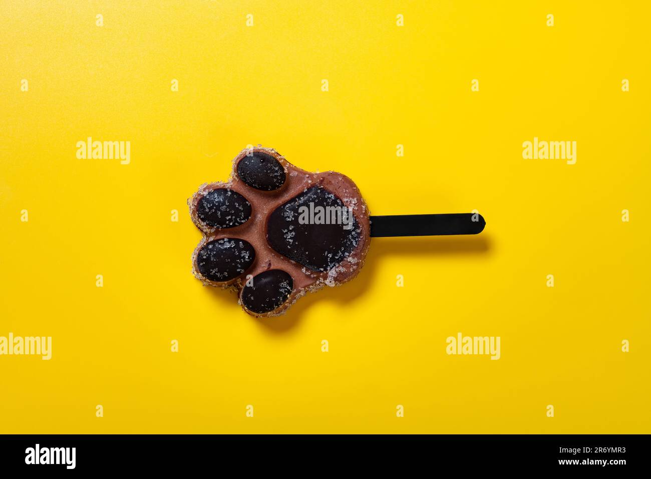 top view bears paw shape chocolate flavor popsicle on yellow background ...