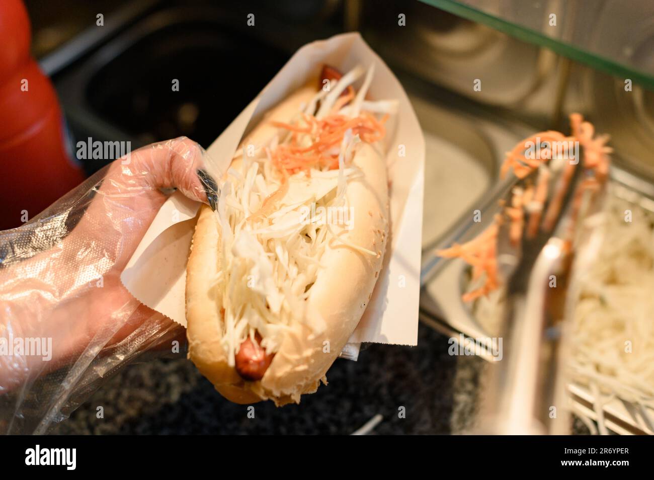 The process of making a hot dog, a worker fulfills a customer's order ...