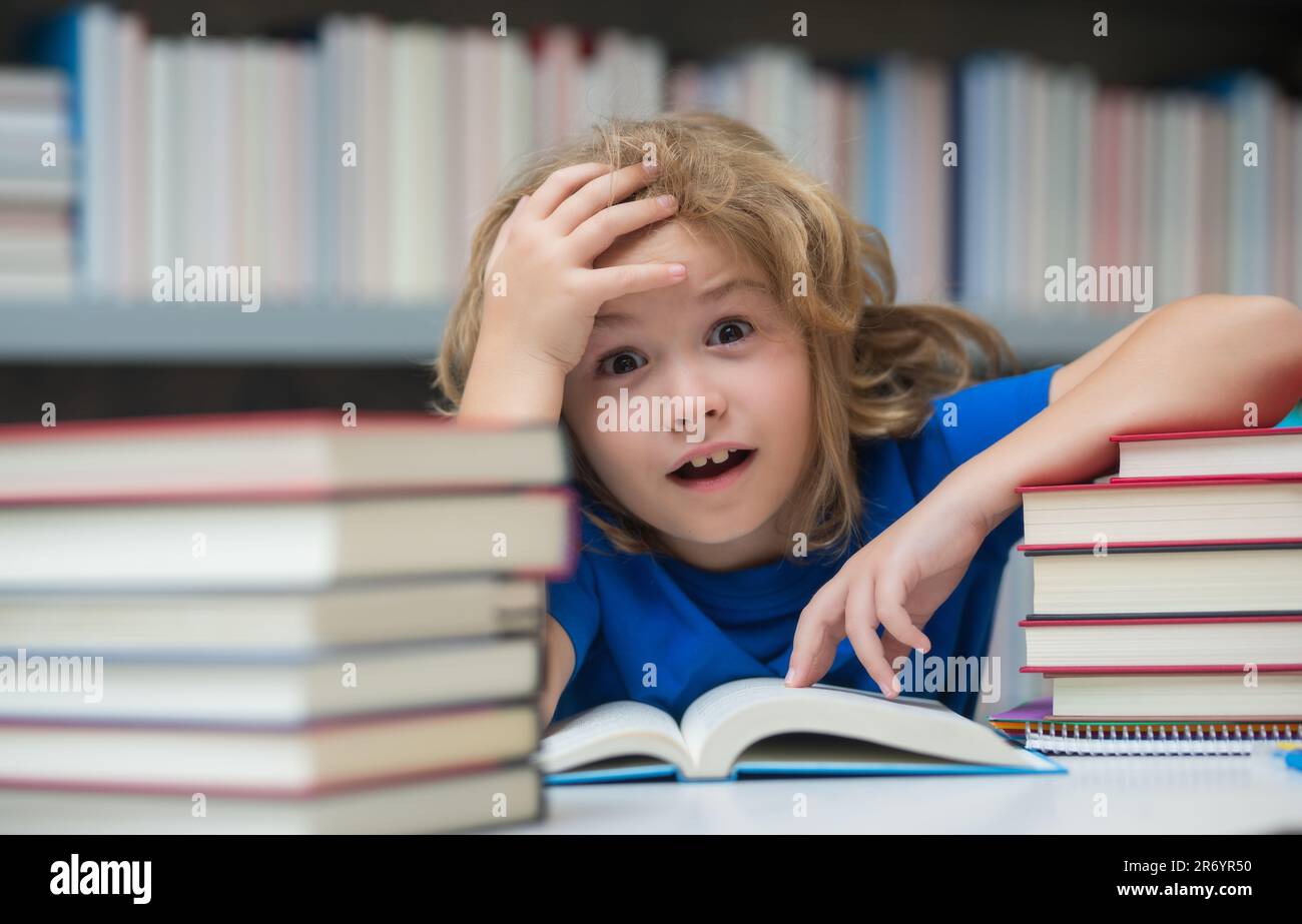 Surprised school kid. Kid on school library. Child reading book at ...