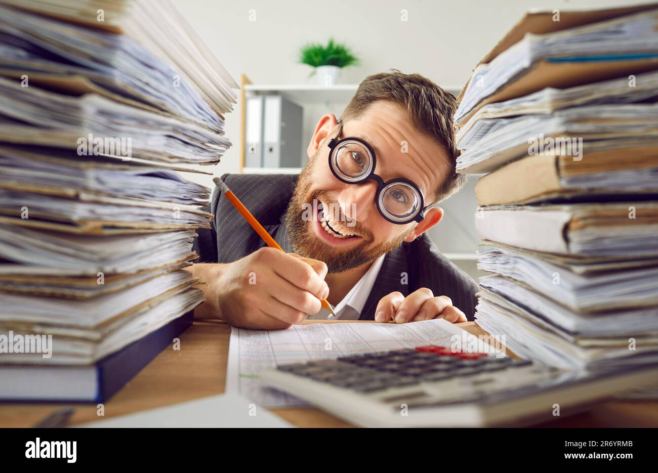 Funny bookkeeper in glasses writes something while doing lots of ...