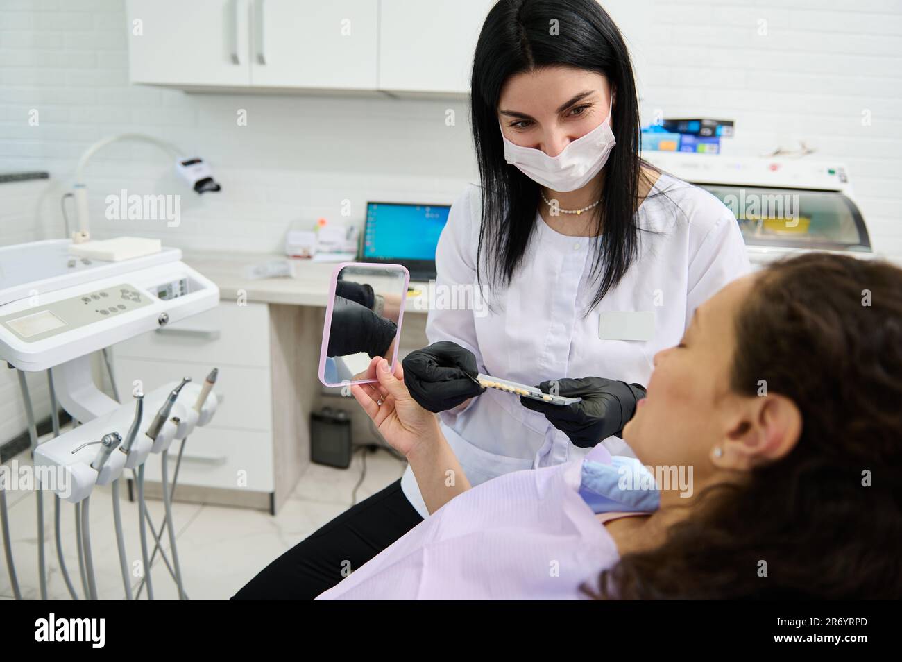 Dentist doctor holding teeth color chart, discussing with patient the ...