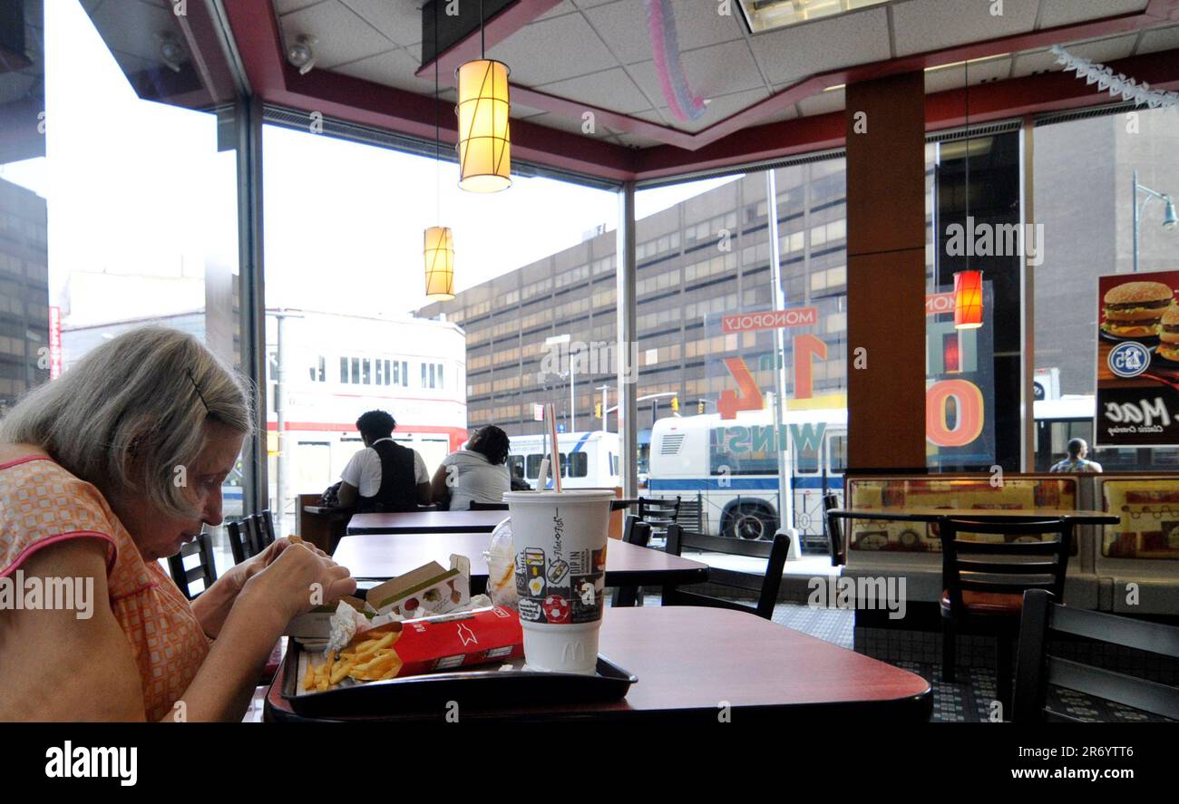 An elderly woman eating fast food in McDonald's in Brooklyn, New York ...
