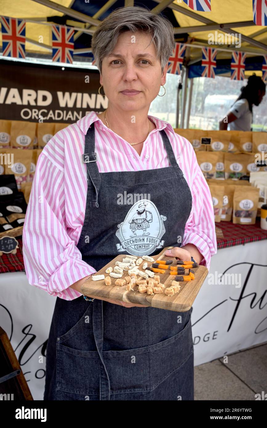 Market trader UK. Woman selling fudge sweet and offering free taste ...