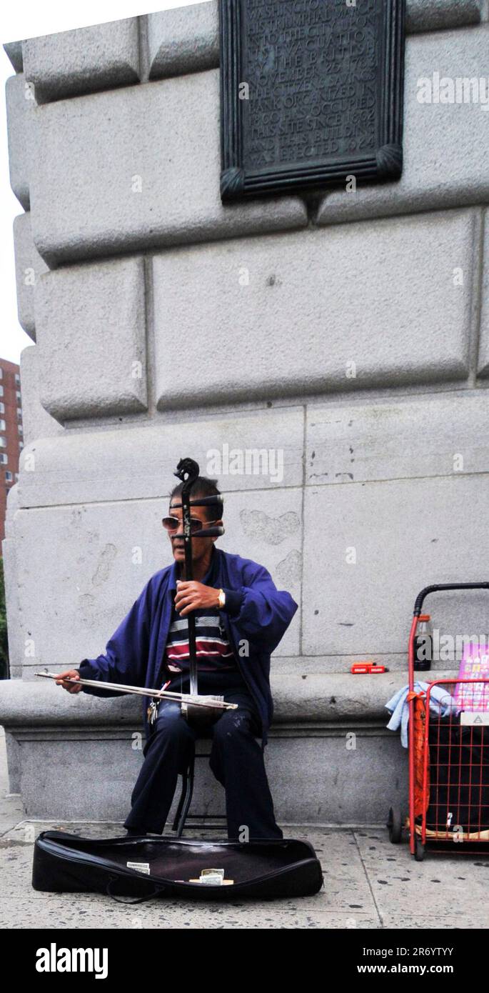 A Chinese man playing his string musical instrument in Chinatown, New ...
