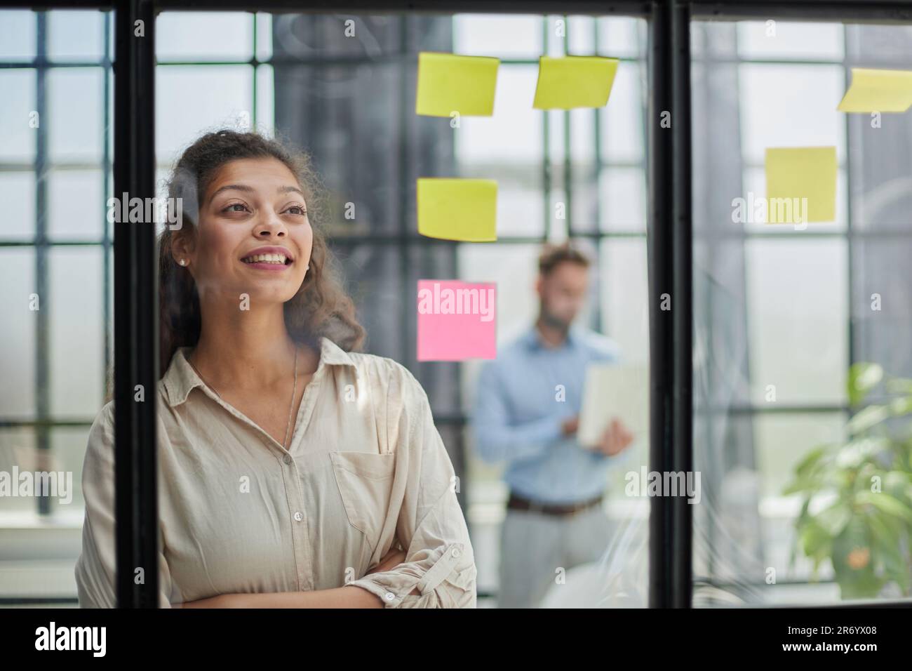 Smiling business woman looking out the window Stock Photo - Alamy