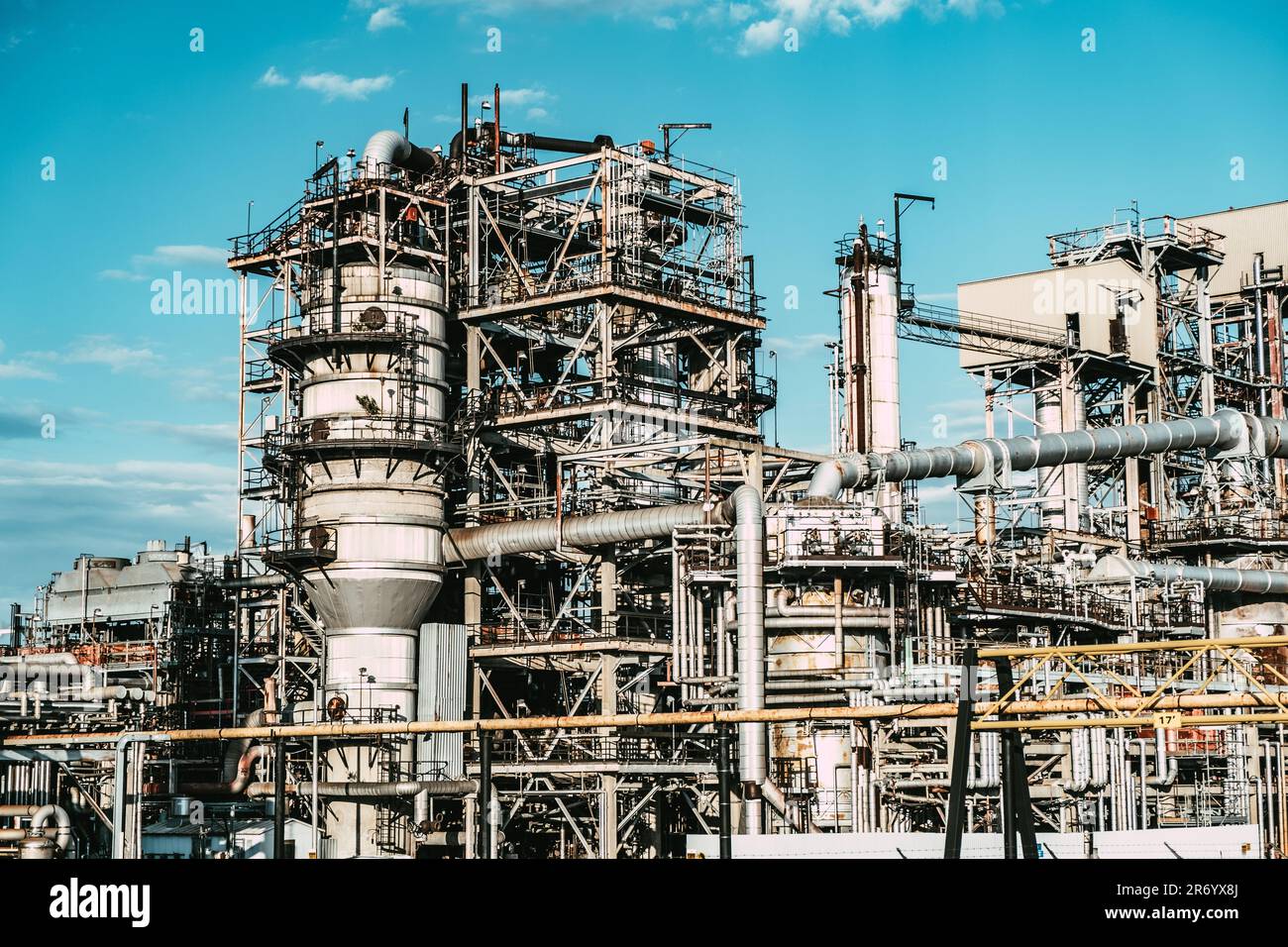 A large industrial building with multiple pipes and chimneys protruding ...