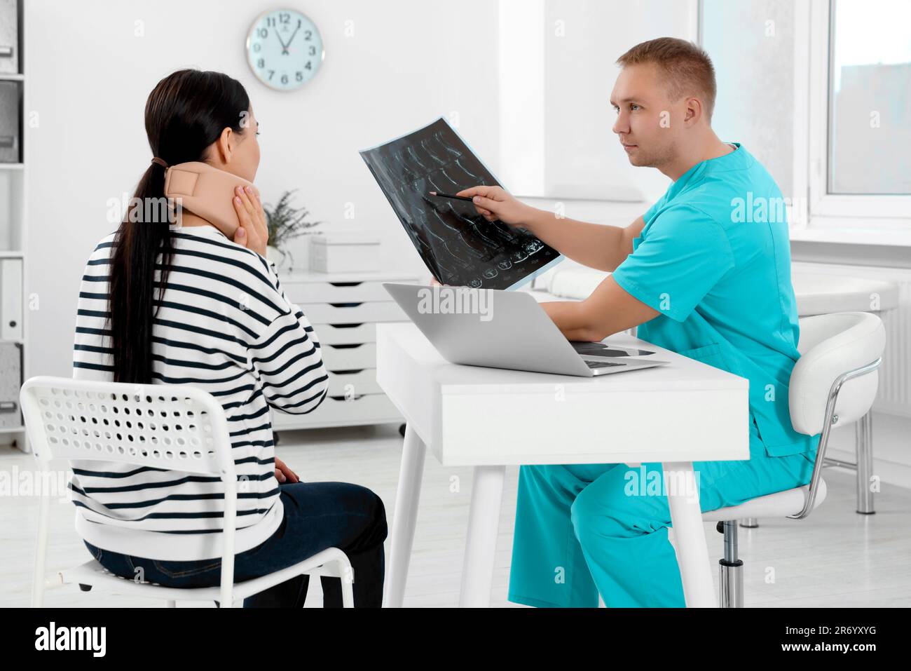 Doctor with neck MRI image consulting patient in clinic Stock Photo - Alamy