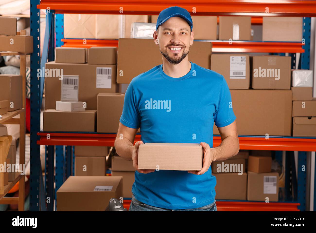 Post office worker with parcel near rack indoors, space for text Stock ...