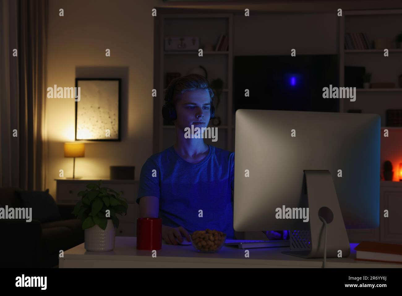 Teenage boy using computer in bedroom at night. Internet addiction ...