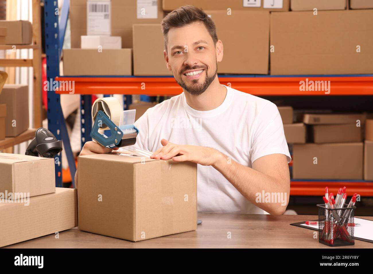 Post office worker packing parcel at counter indoors Stock Photo - Alamy