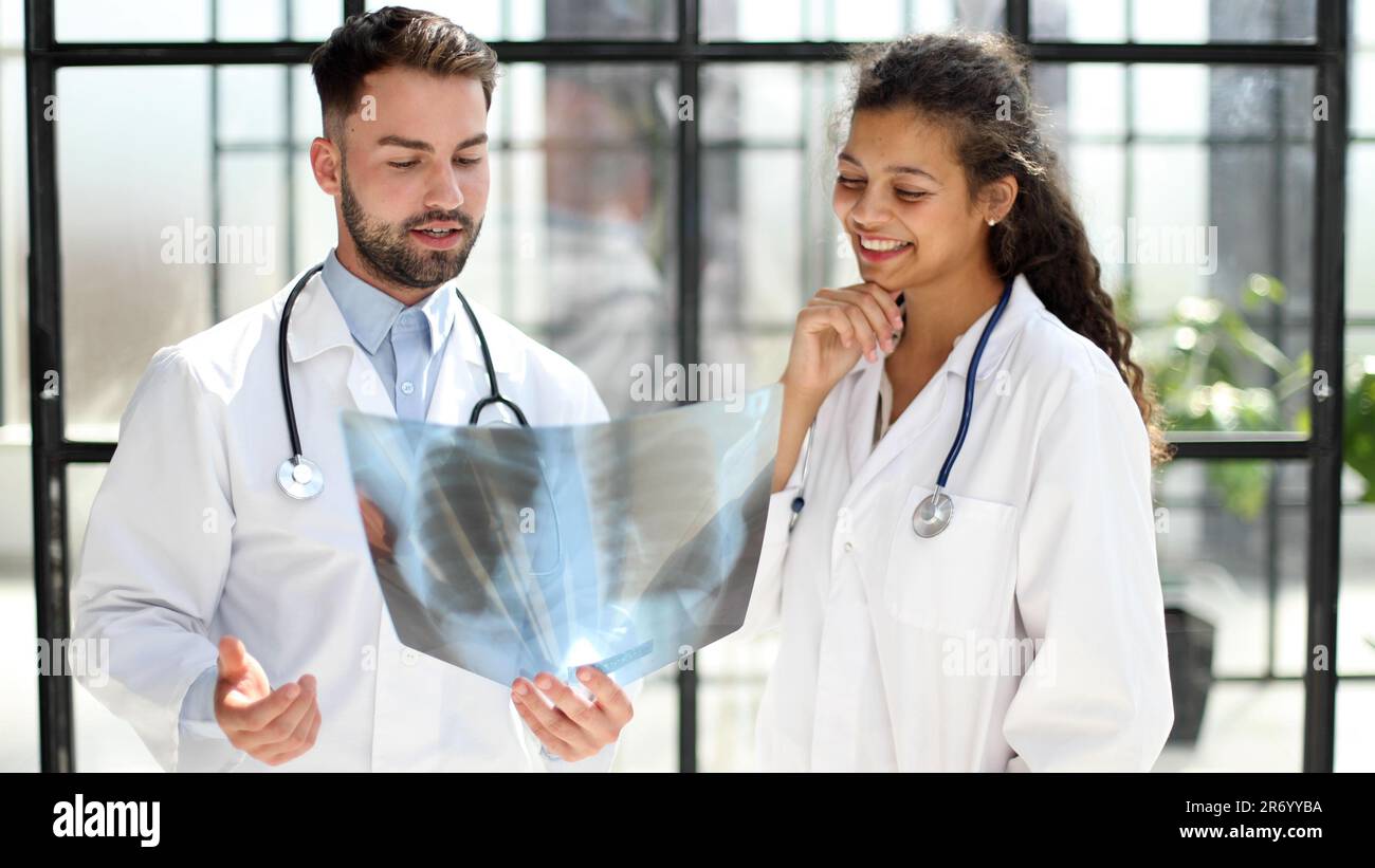 Two busy doctors working with papers and xray images Stock Photo - Alamy