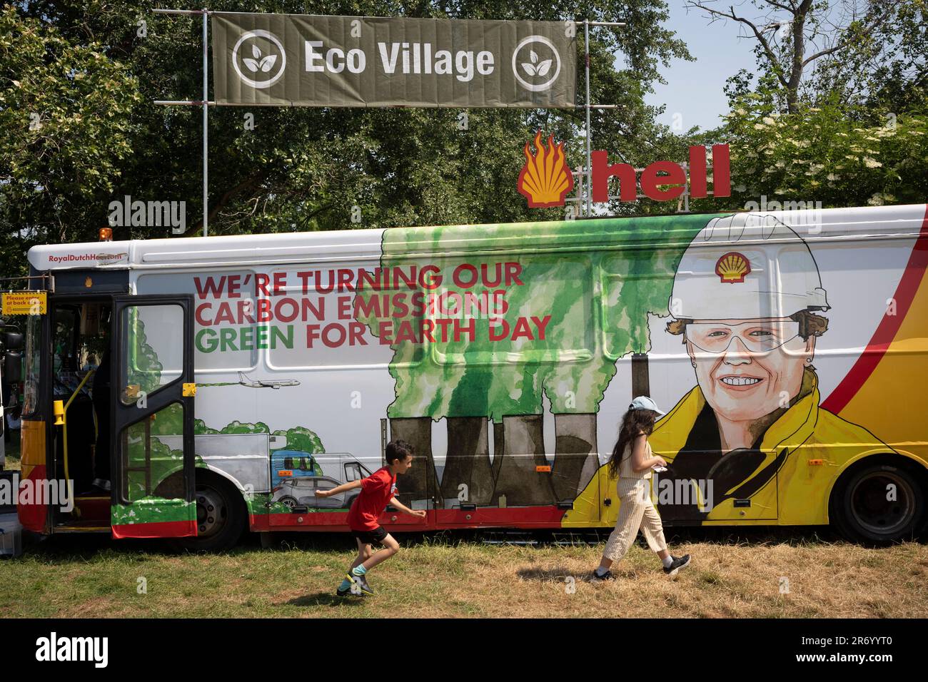 Children run past a Climate Change bus parody that illustrates cooling ...