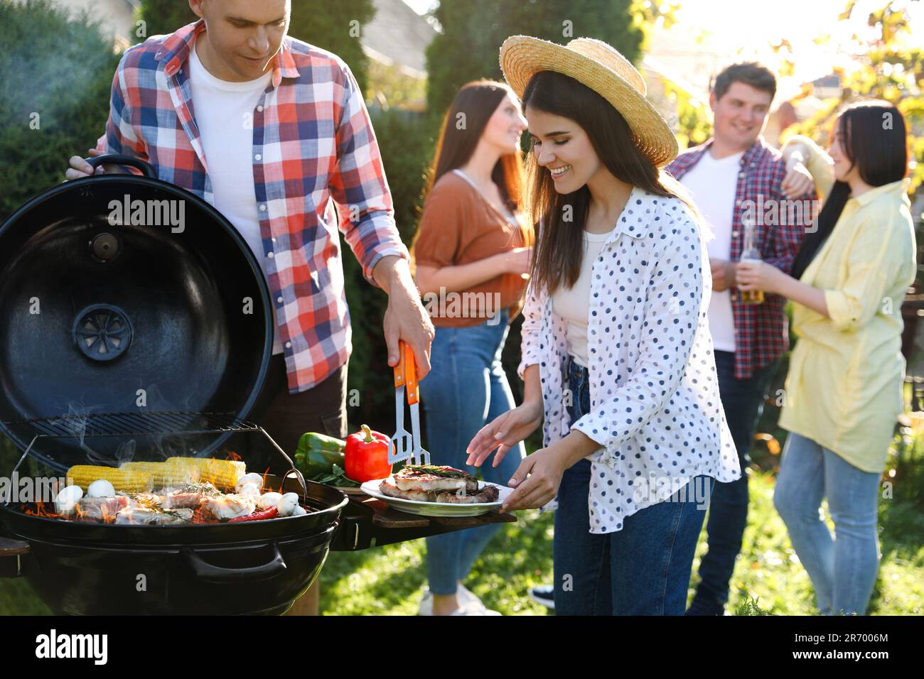 People with drinks having barbecue party outdoors Stock Photo - Alamy
