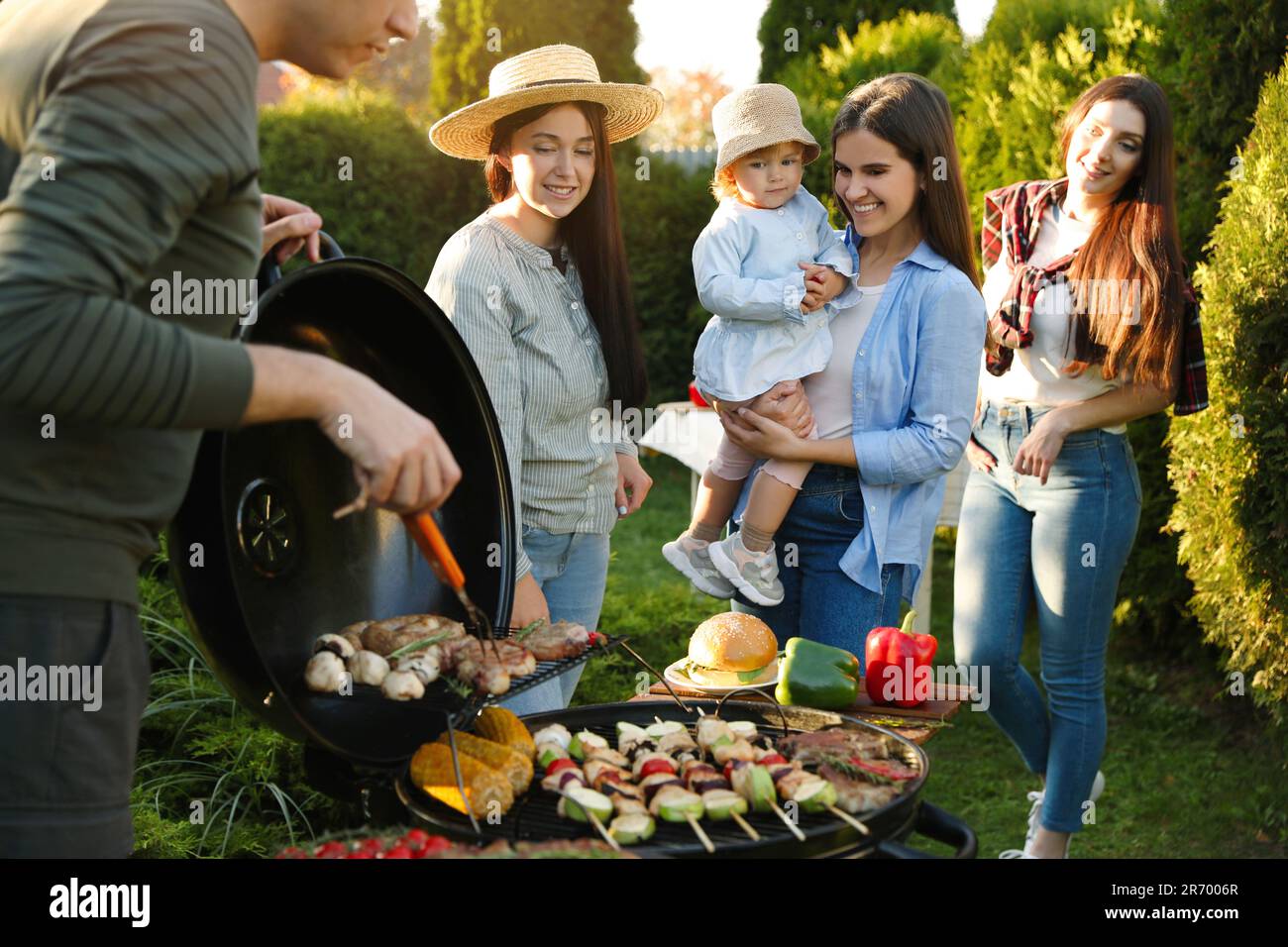 Family with friends having barbecue party outdoors Stock Photo - Alamy