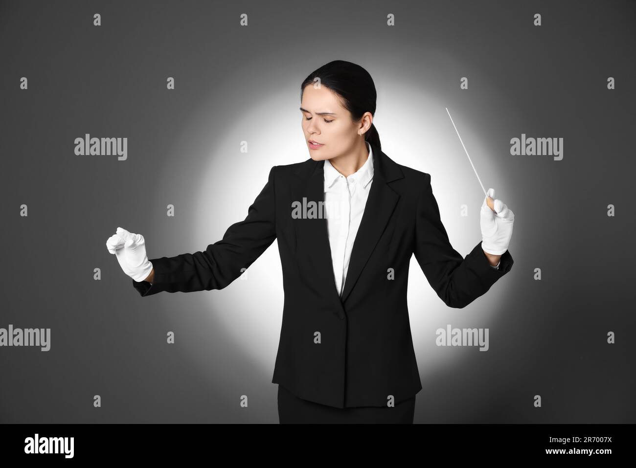 Professional conductor with baton on grey background Stock Photo - Alamy