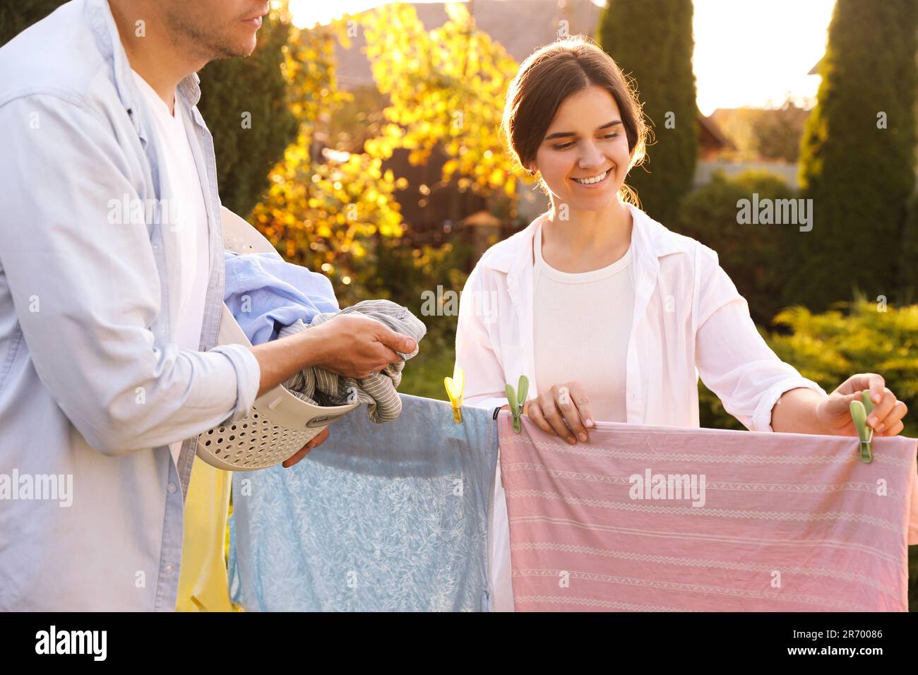 Happy family hanging clothes with clothespins on washing line for ...