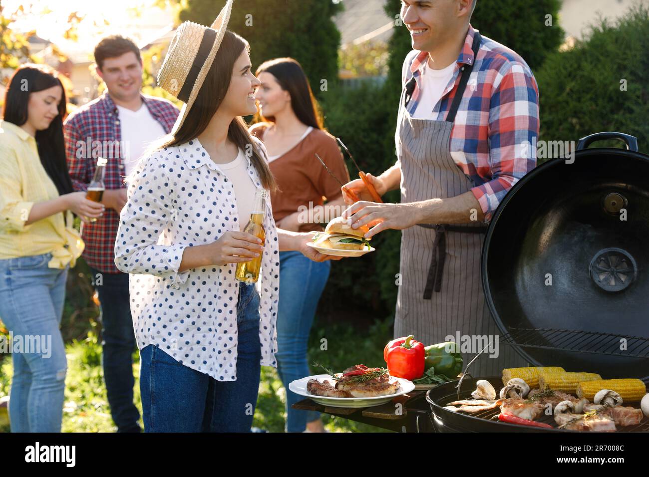 People with drinks having barbecue party outdoors Stock Photo - Alamy