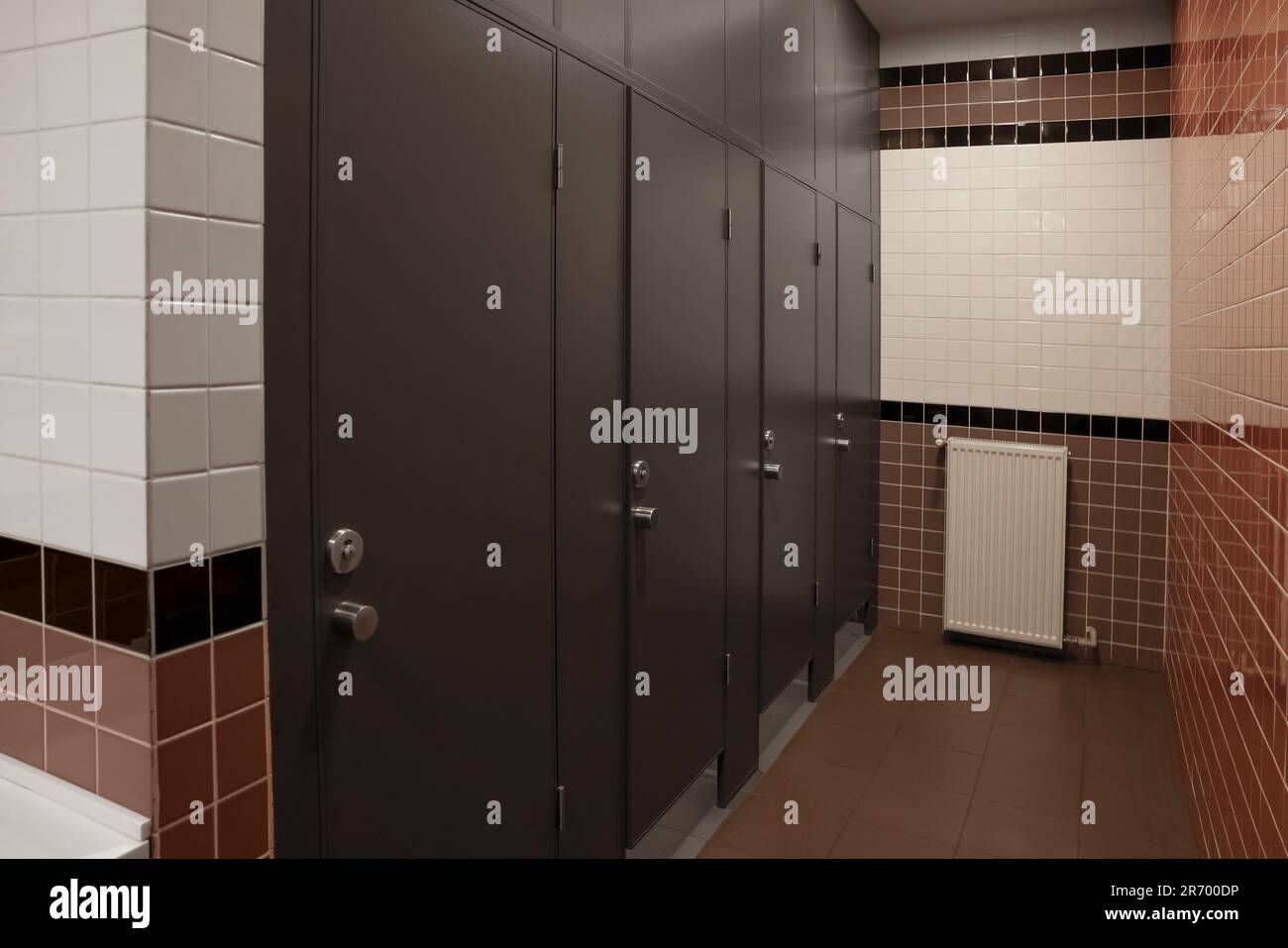 Public toilet interior with stalls and tiled walls Stock Photo - Alamy